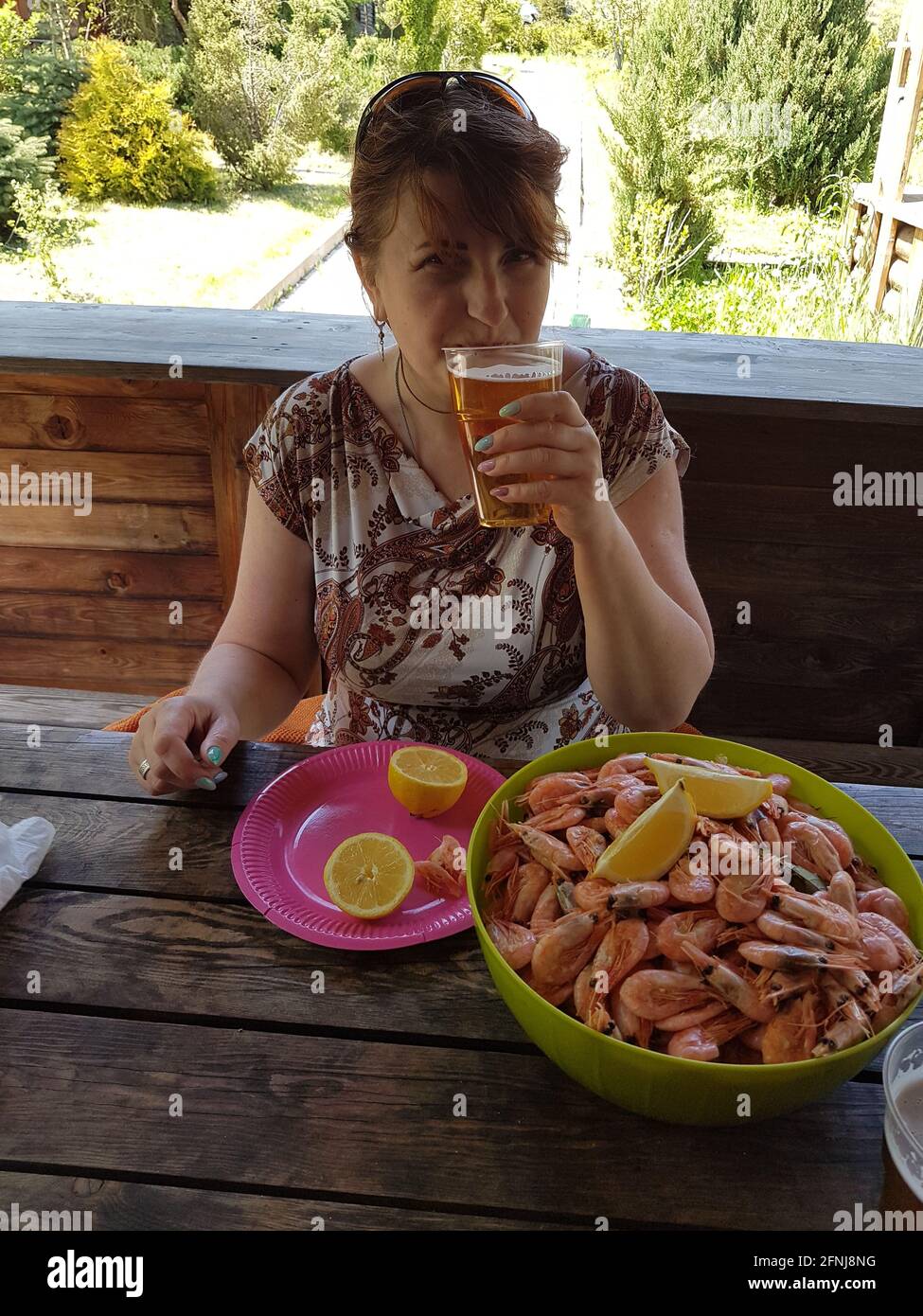 Woman eating shrimp and drinking beer Stock Photo - Alamy