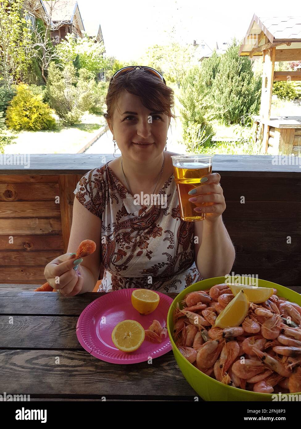 Woman eating shrimp and drinking beer Stock Photo - Alamy