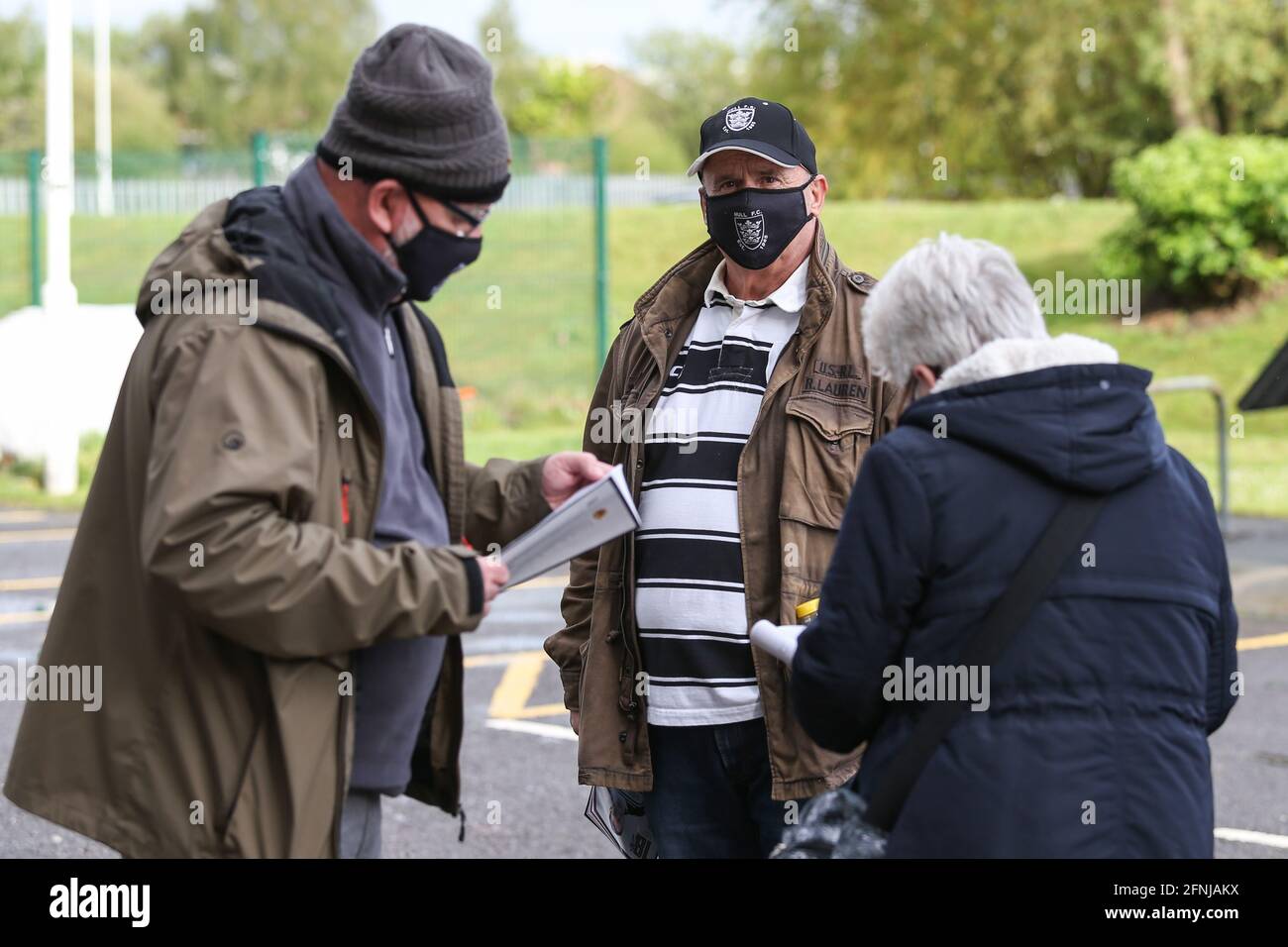 Hull FC fans read the match programme while waiting for the turnstiles ...