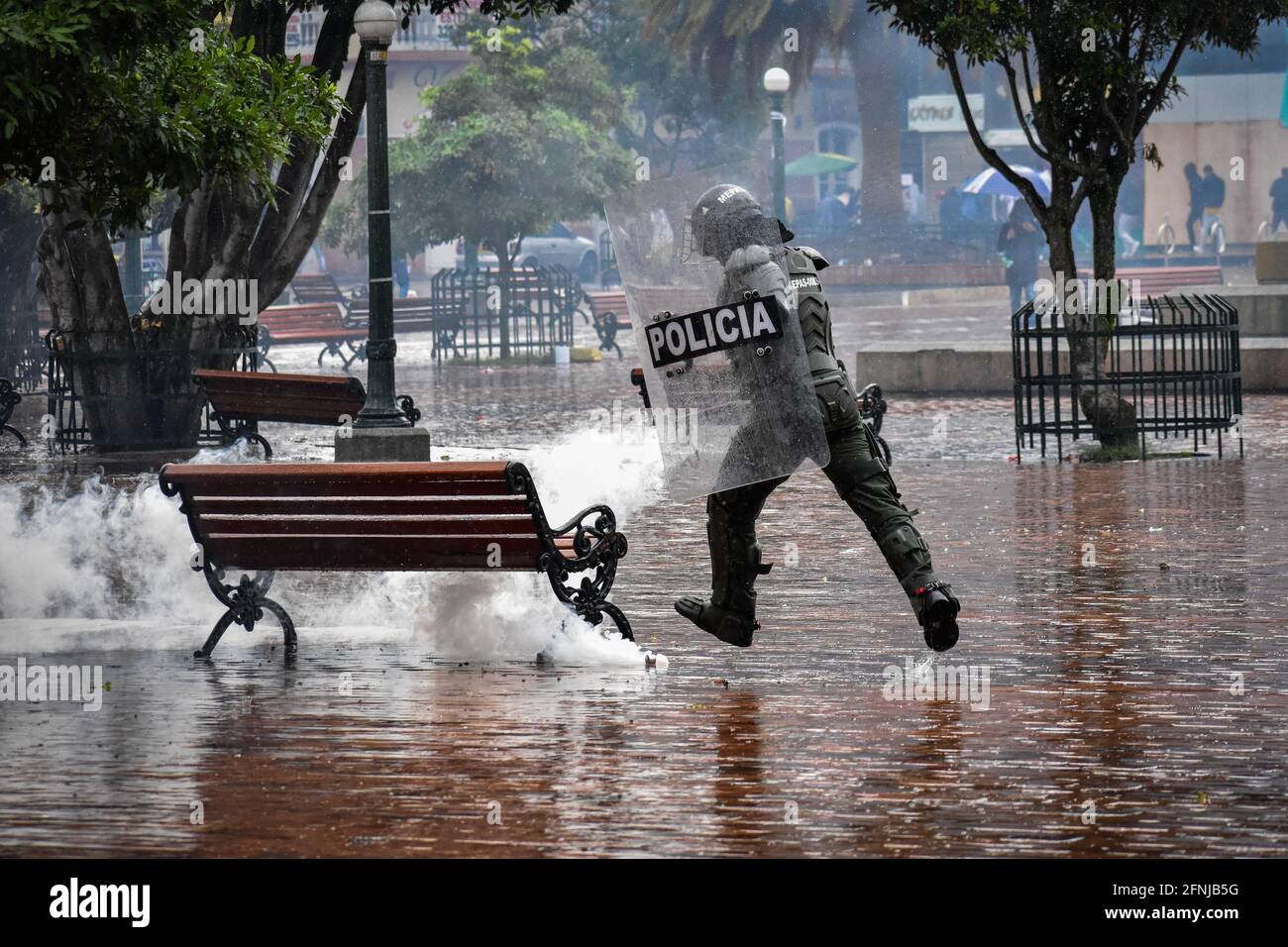 Riot police runs to return tear gas grenade to demonstrators in Pasto ...