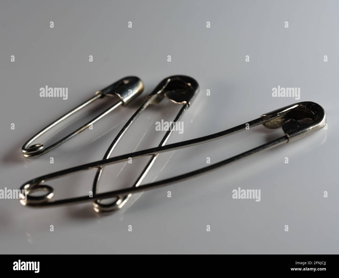 Closeup shot of three safety pins Stock Photo - Alamy