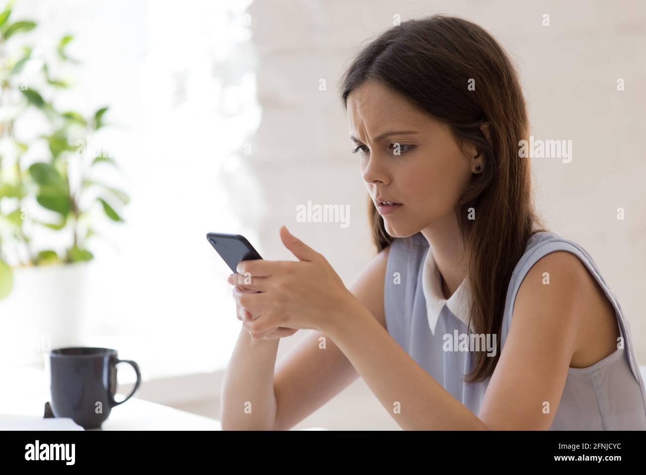 Unhappy young woman frustrated by bad message on cell Stock Photo - Alamy