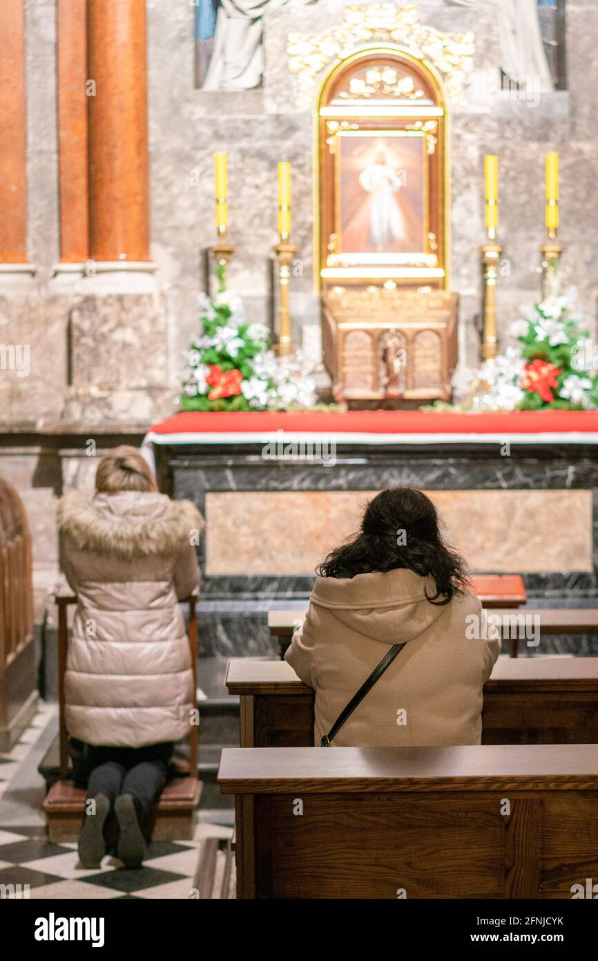 A woman in a temple prays to God. Woman praying in front of altar ...