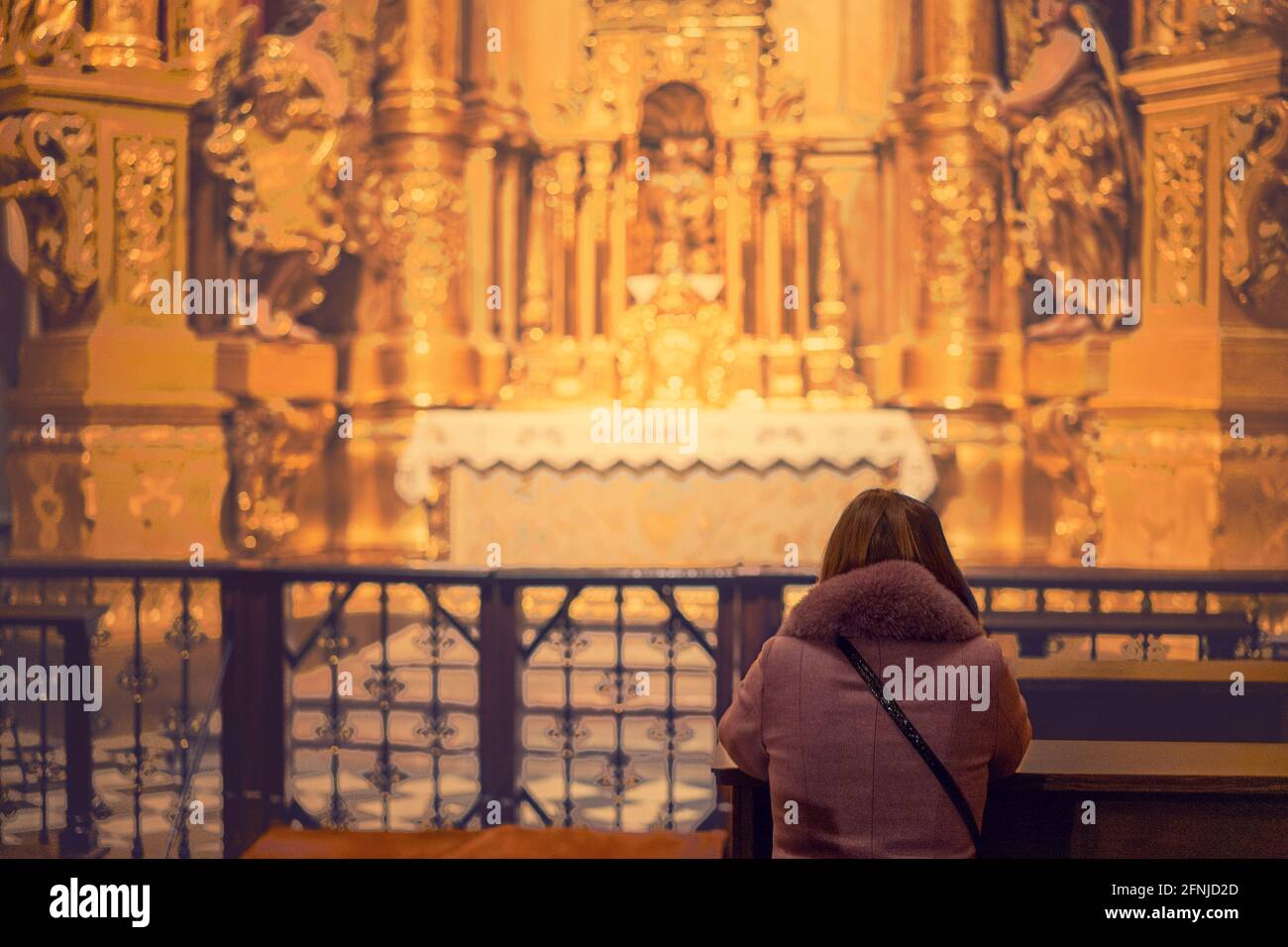 A woman in a temple prays to God. Woman praying in front of altar ...