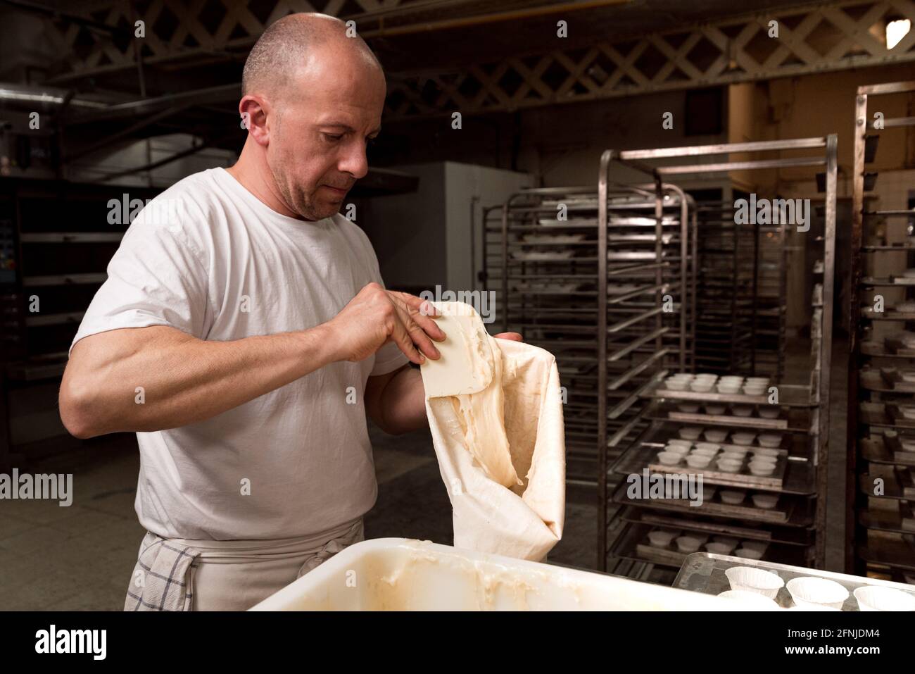 pastry chef in pastry shop filling stamps and cream. concept of ...