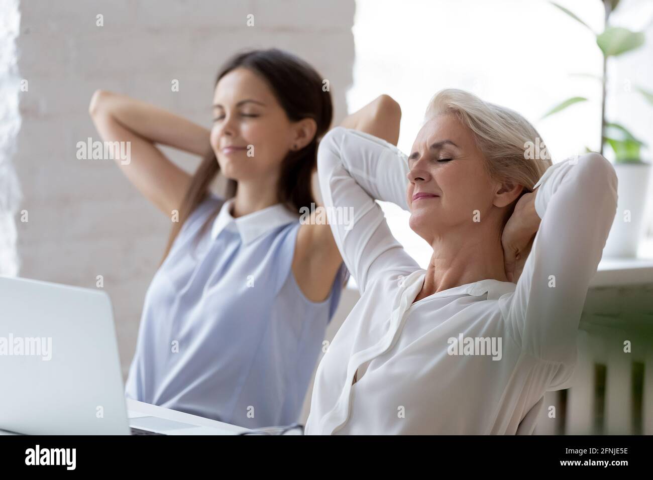 Calm female colleagues relax sitting at office desk Stock Photo - Alamy
