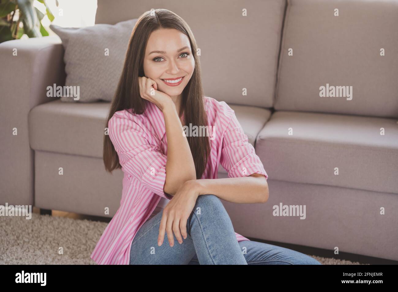 Photo Of Pretty Happy Nice Young Lady Sit Floor Hold Hand Cheekbone