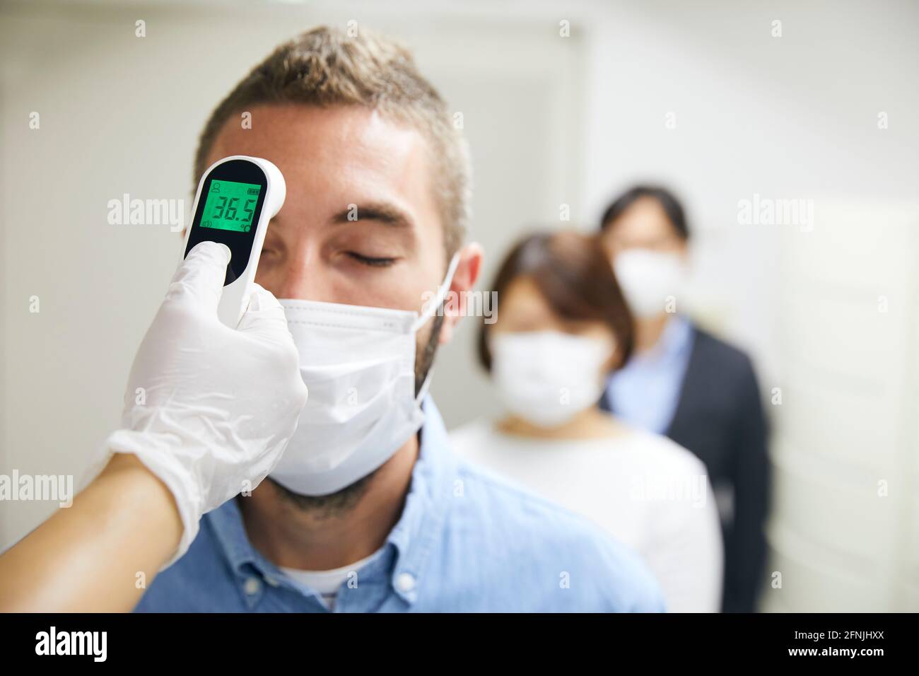 Checking body temperature in the office Stock Photo - Alamy