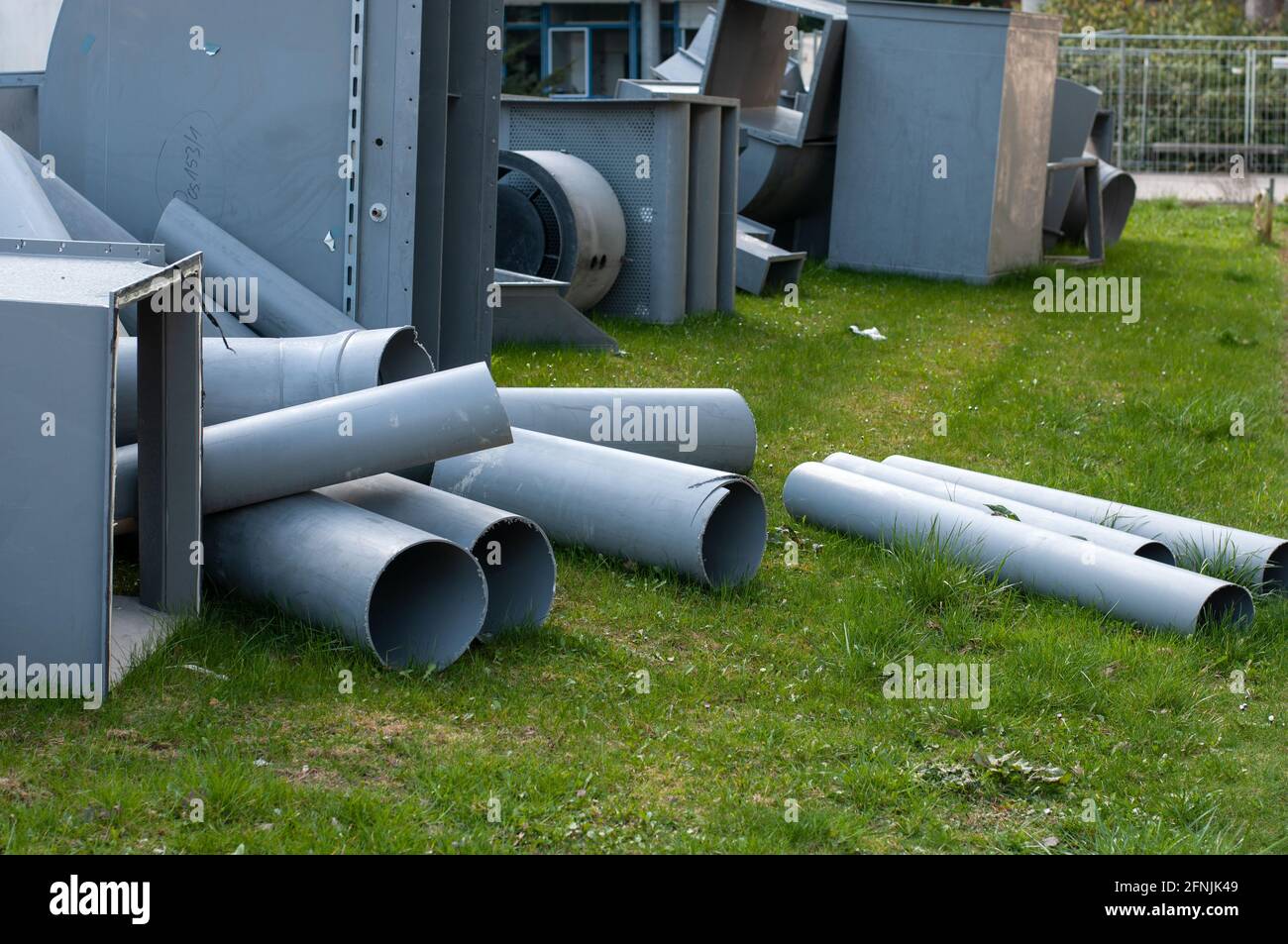 gray plastic pipes in a meadow after the demolition of an air condition ...