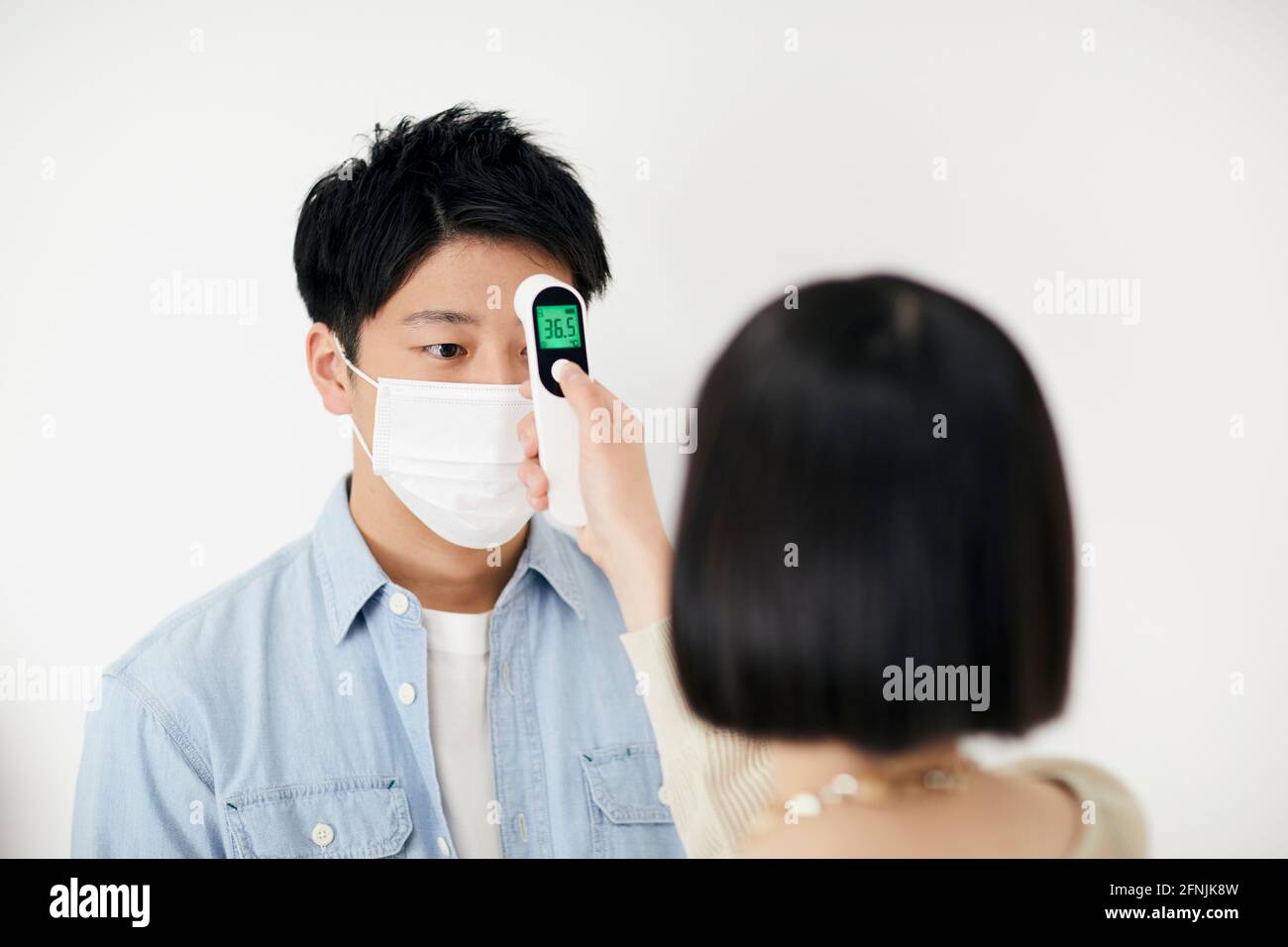 Checking body temperature in the office Stock Photo - Alamy