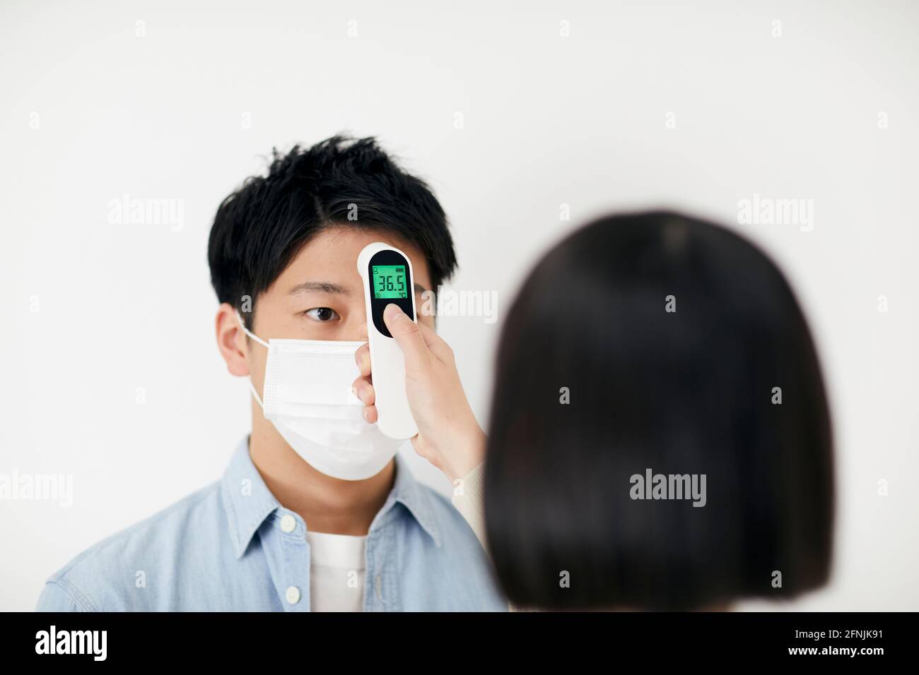 Checking body temperature in the office Stock Photo - Alamy
