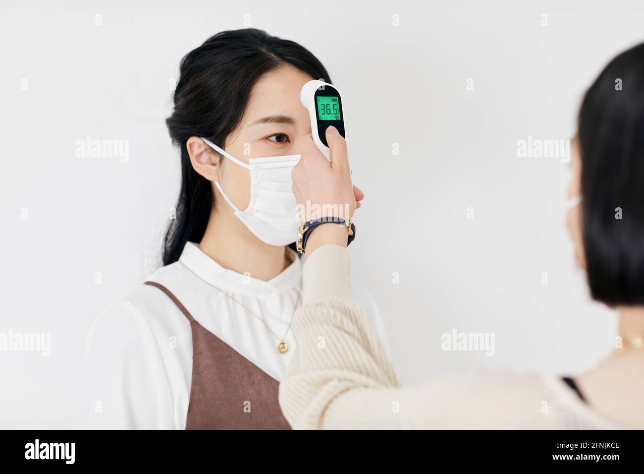 Checking body temperature in the office Stock Photo - Alamy