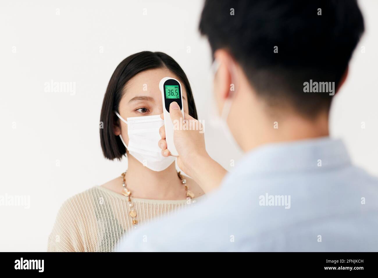 Checking body temperature in the office Stock Photo - Alamy