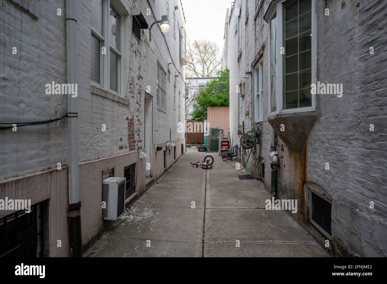 Alley between the white brick wall buildings Stock Photo - Alamy