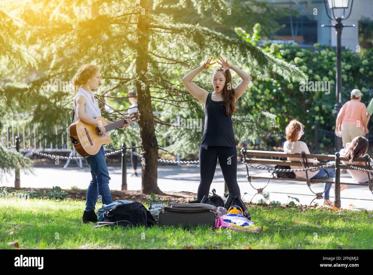 Two young women singing in the public park in New York City in summer ...