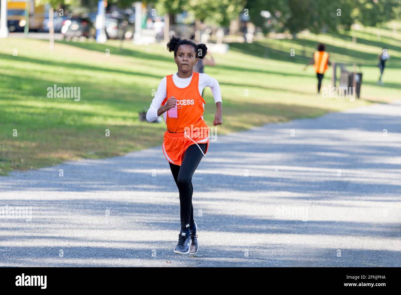 Young girl running in the school competition at the park in New York ...