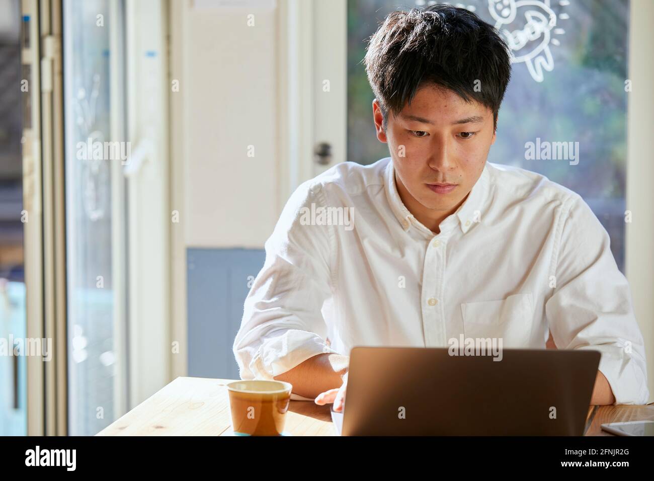 Young Japanese man at a cafe Stock Photo - Alamy