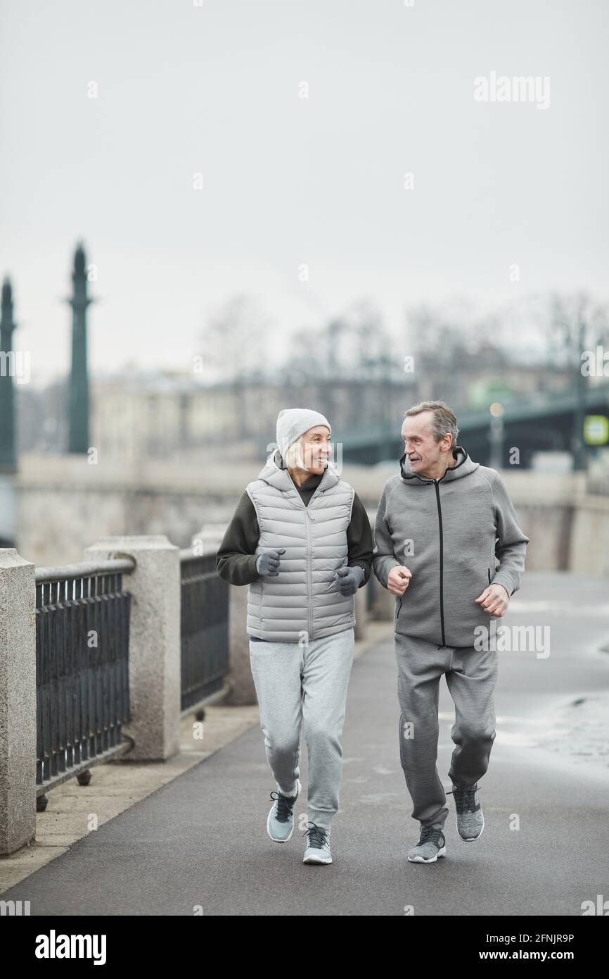 Happy active senior Caucasian couple in gray sport suits chatting and ...