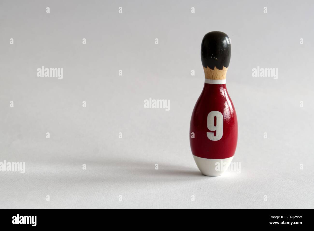 rearview of a wooden puppet in the shape of a bowling pin with a number ...
