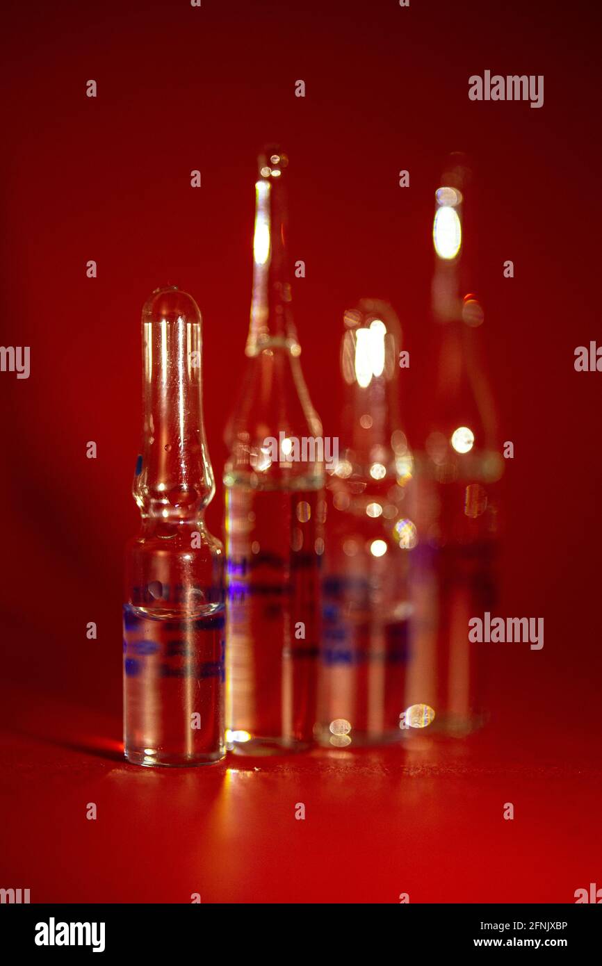 medical injection vials on a red background Stock Photo - Alamy