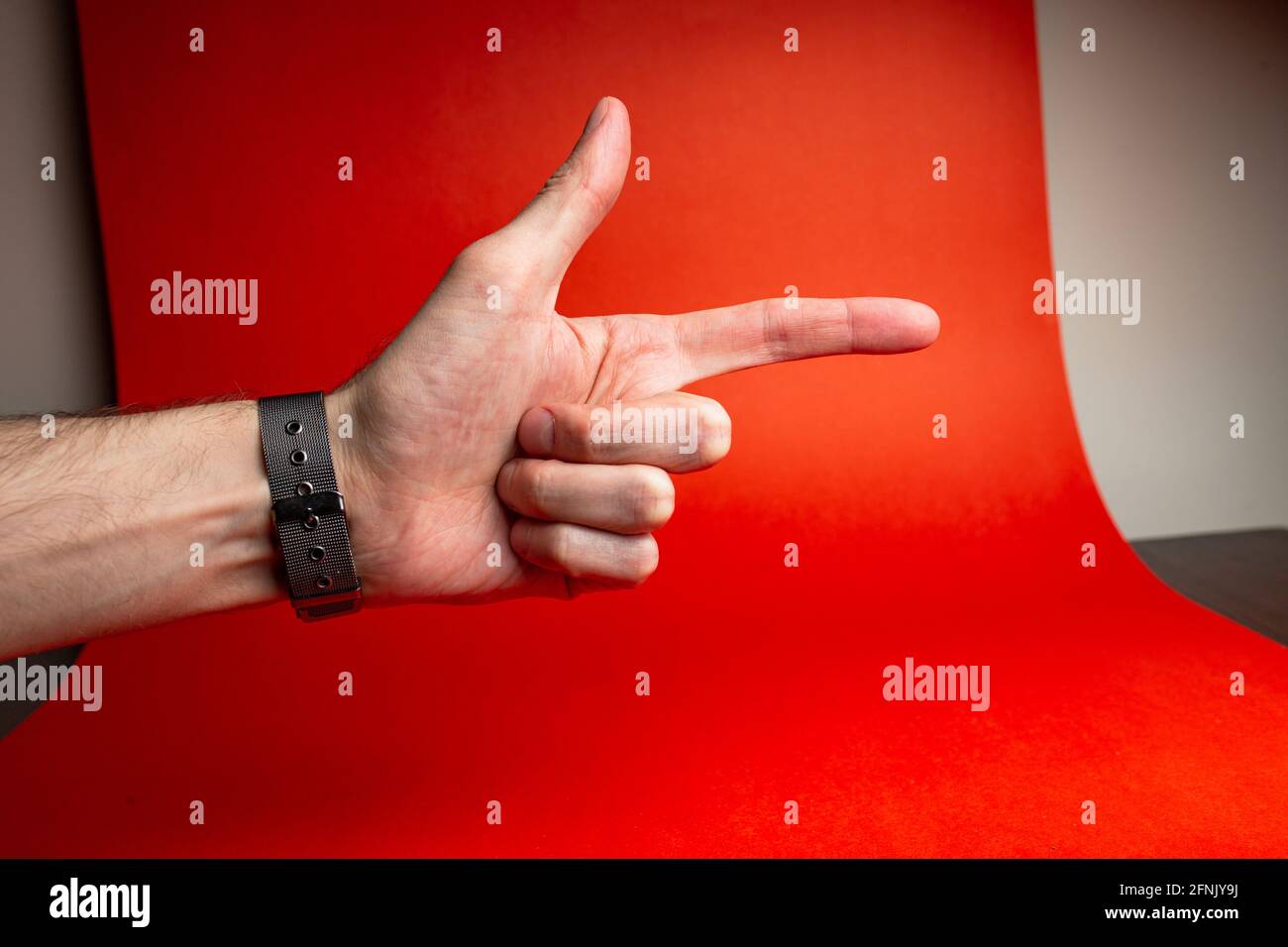 man's hand points finger at red background Stock Photo - Alamy