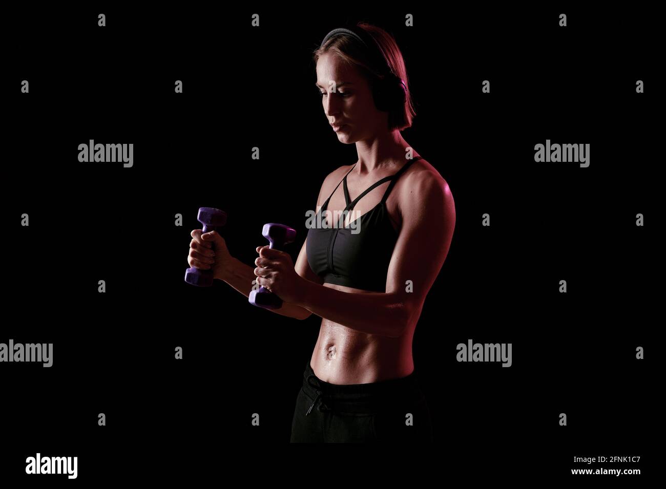 Young strong woman with perfect abdomen and strong arms exercise with ...