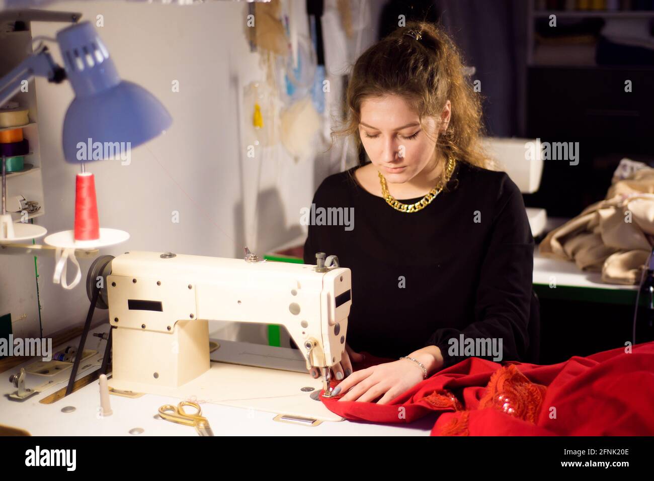 Dressmaker working on the sewing machine. Tailor making a garment ...