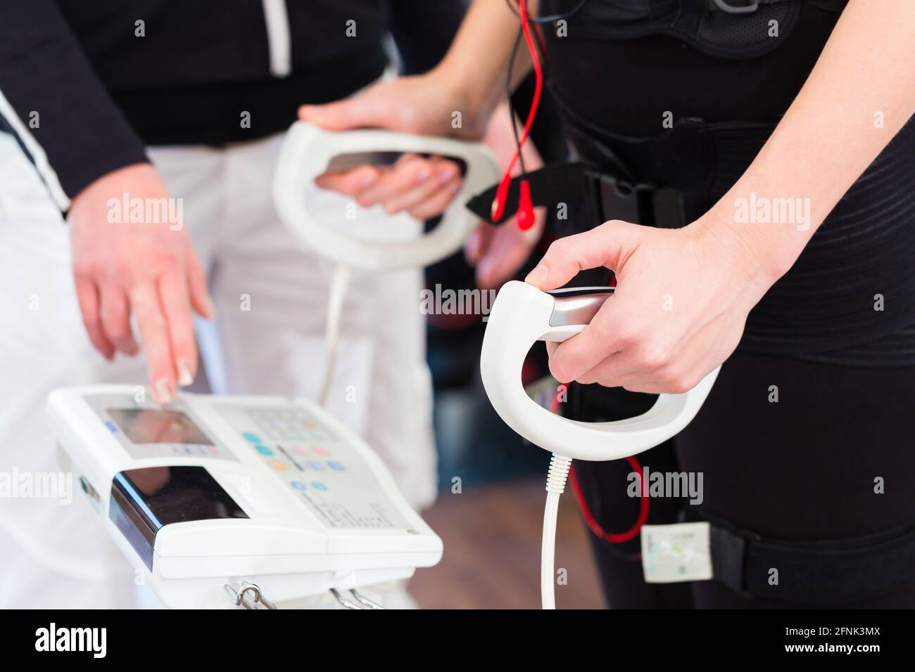 Female coach controlling results after ems electro muscular stimulation ...