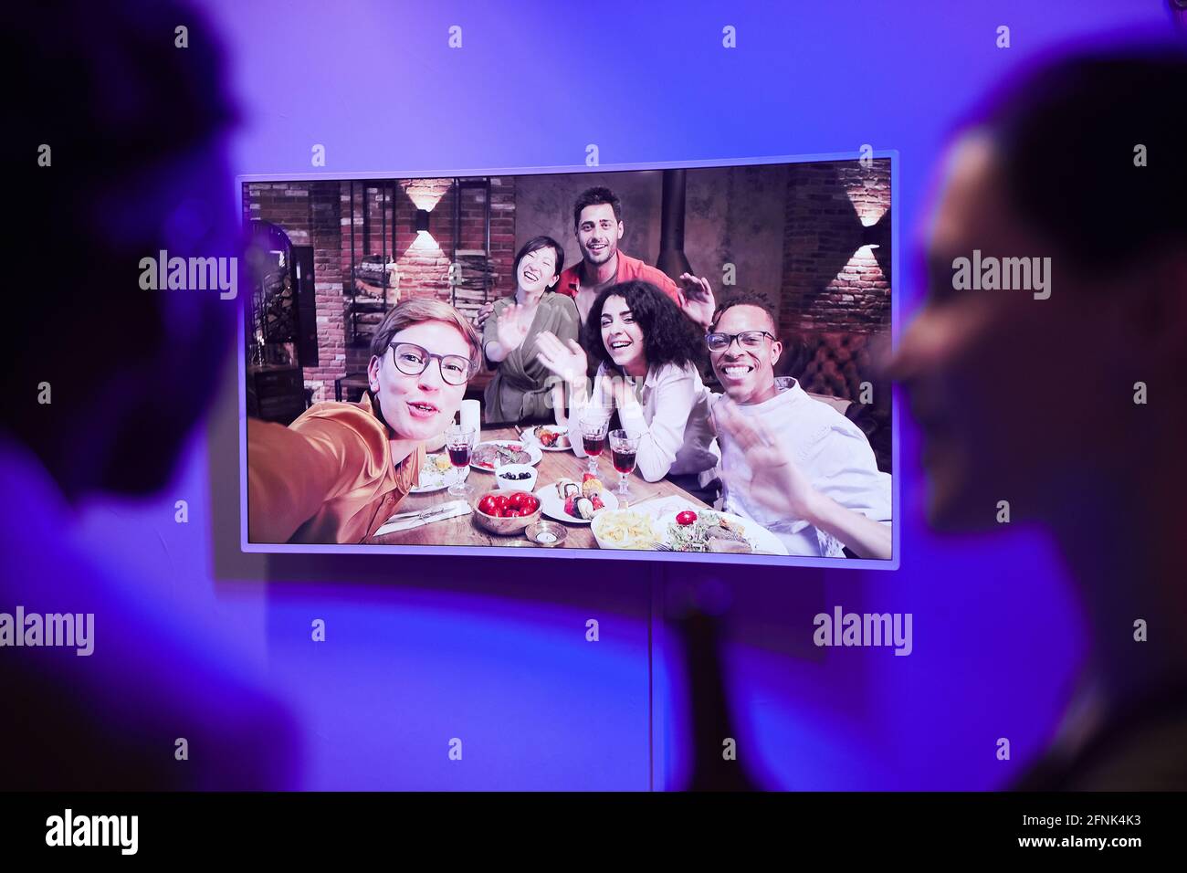 Group of young people celebrating on TV screen, online party concept ...