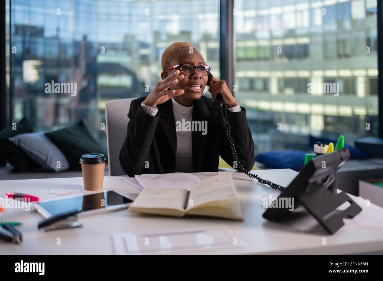 Angry black manager talking on telephone Stock Photo - Alamy