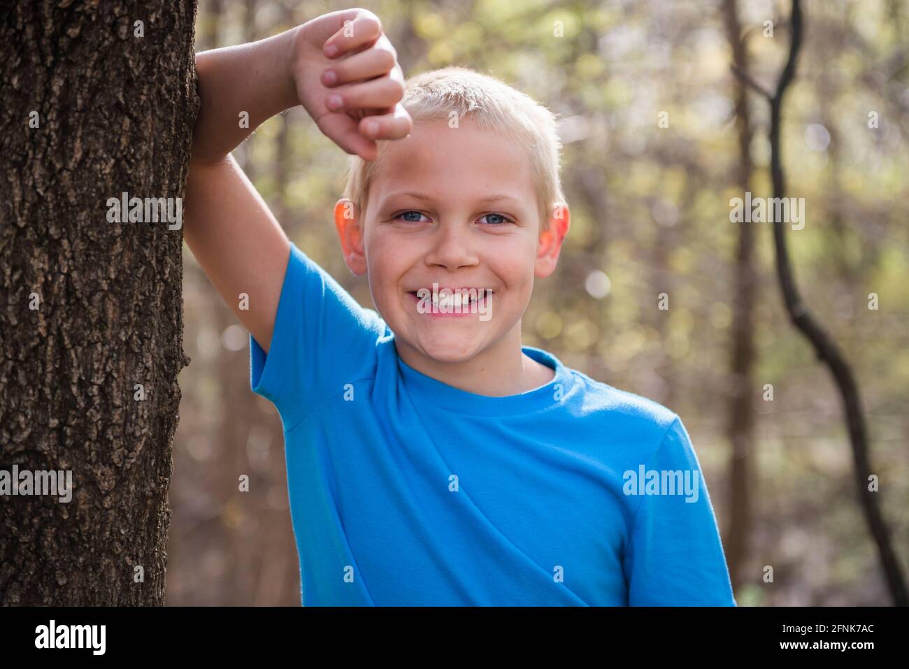 Kid leaning against tree hi-res stock photography and images - Alamy