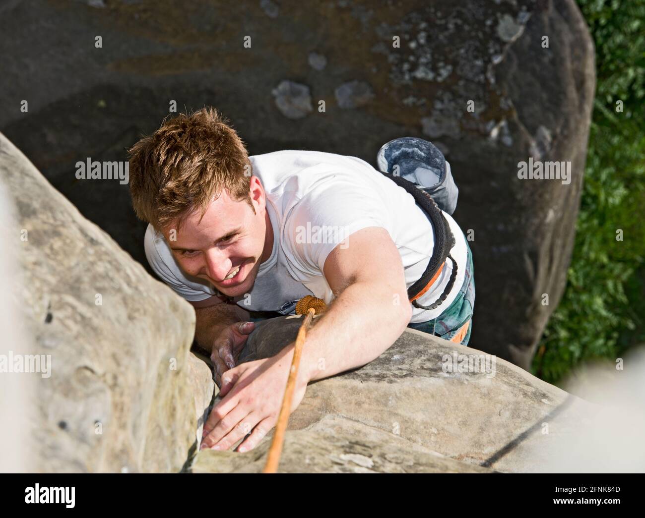 man climbing on the sandstone rocks at Harrison's Rock in England Stock ...