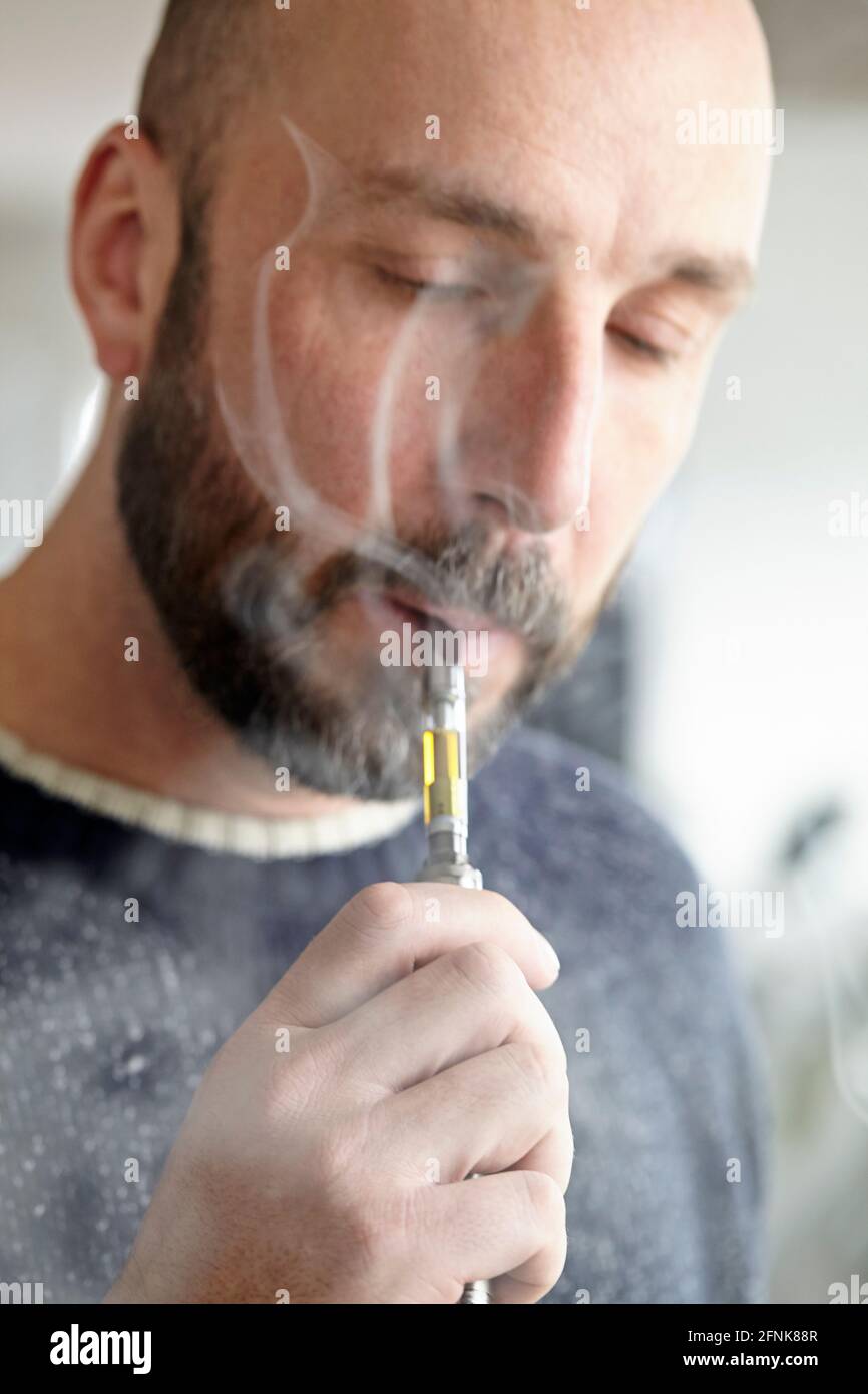 man vaping cannabis distillate with vape pen Stock Photo - Alamy