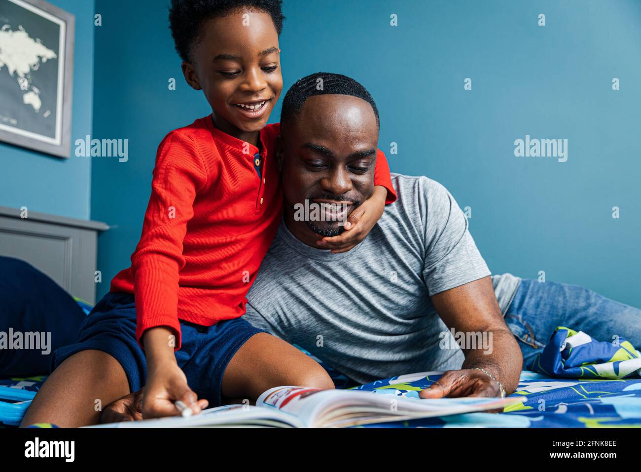 Father and son having fun doing homework on bed at home Stock Photo - Alamy