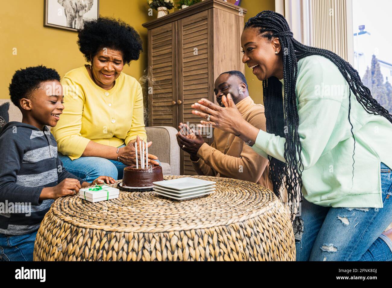 Happy multi-generational family celebrating birthday together at home ...