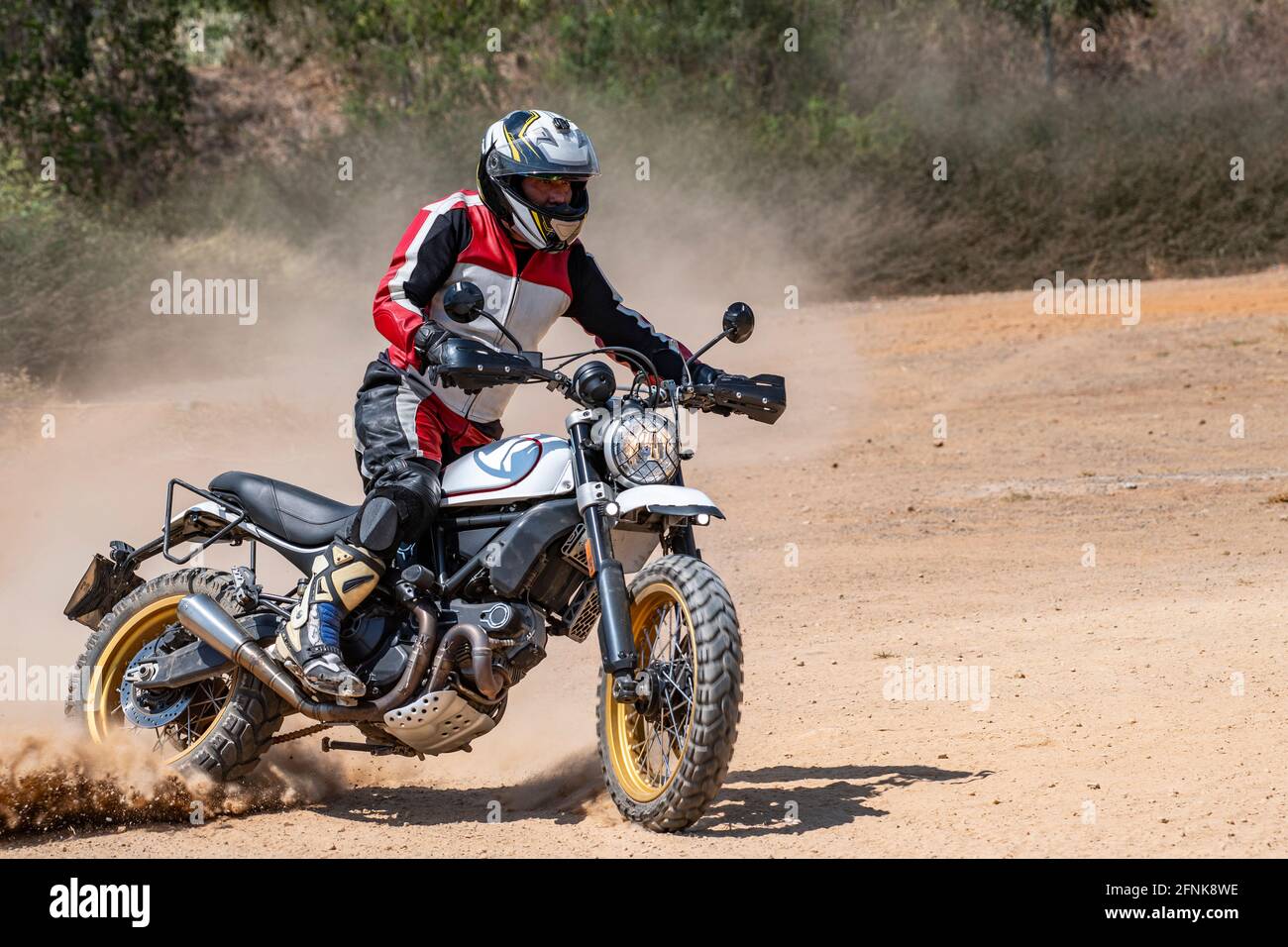 man drifting his scrambler type motorcycle on dirt track in Thailand ...