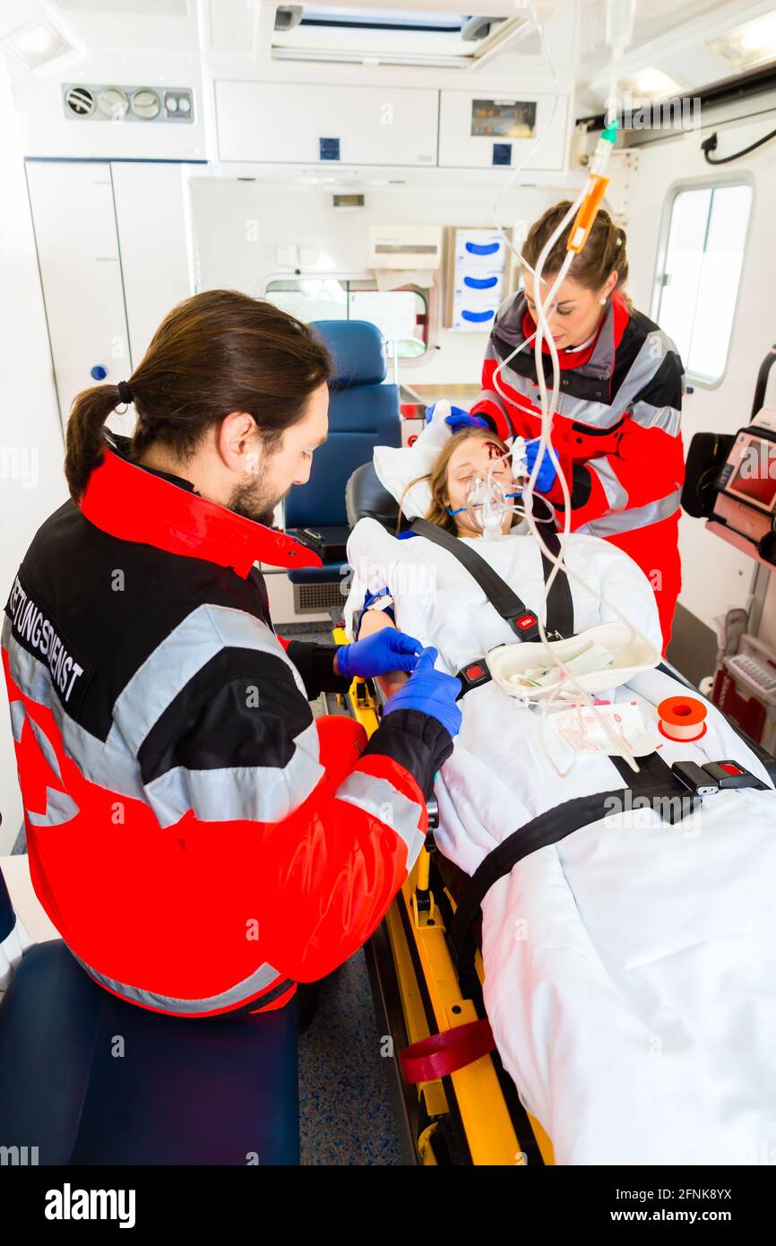 Emergency doctor and nurse or ambulance team medicate accident victim ...