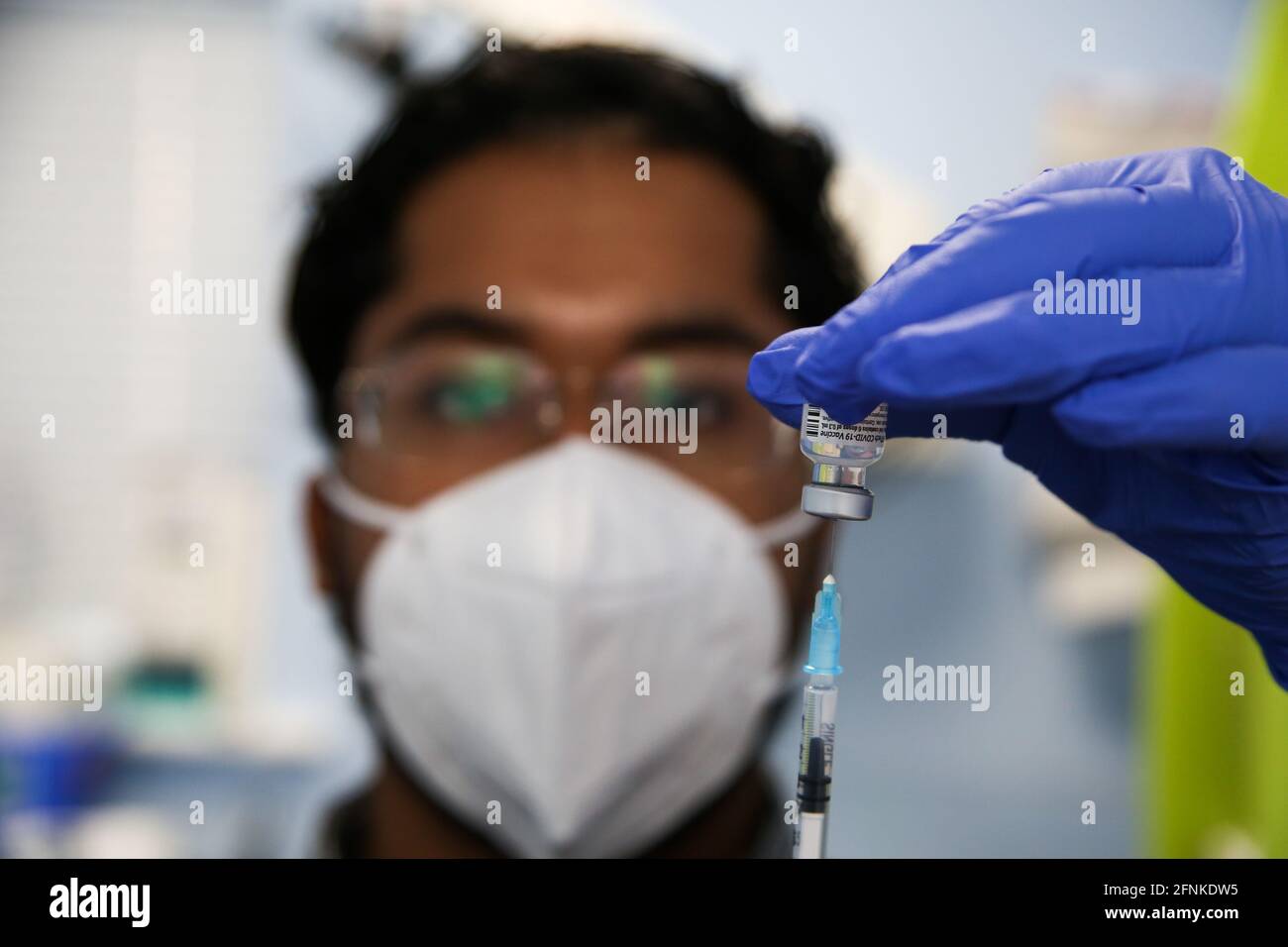 London, UK. 15th May, 2021. A healthcare worker prepares a dose of ...