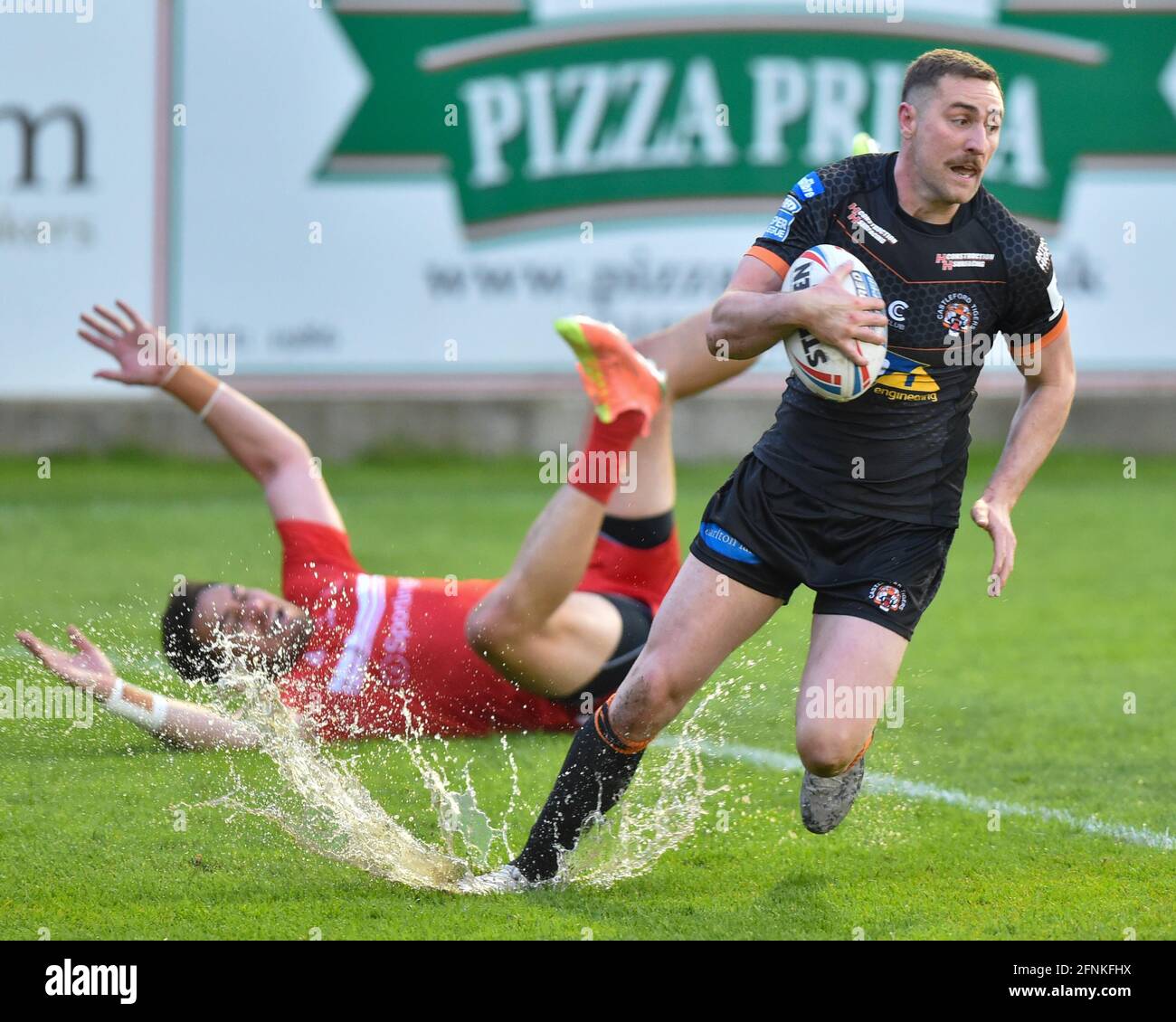 James Clare (20) of Castleford Tigers makes a splash as he evades the ...