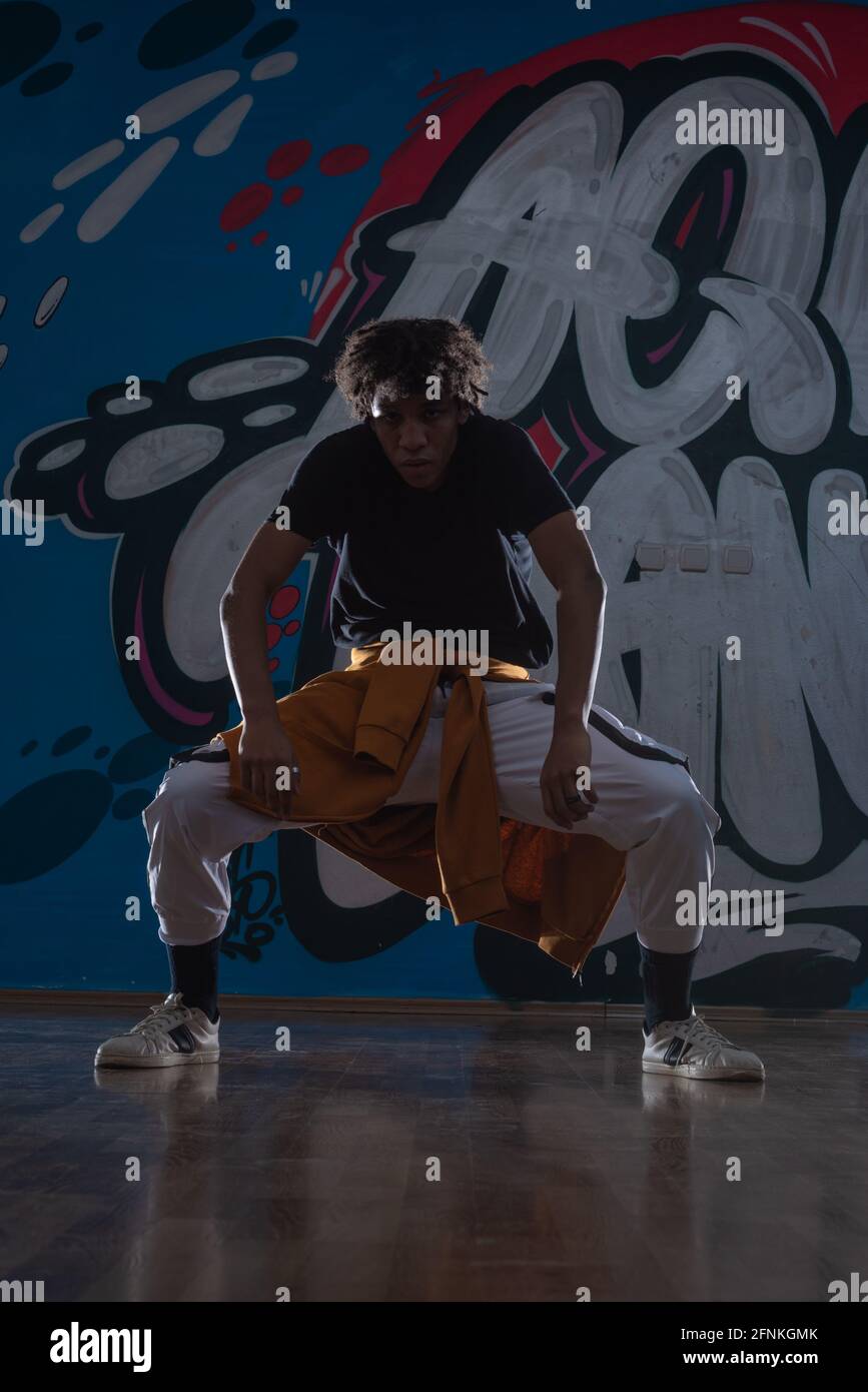 African American hip hop dancer (breakdancer) performing over graffiti ...