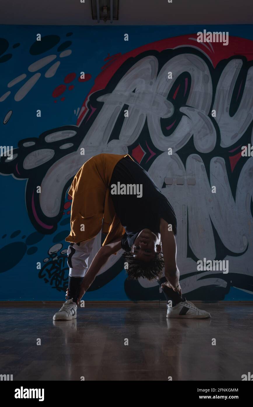African American hip hop dancer (breakdancer) performing over graffiti ...