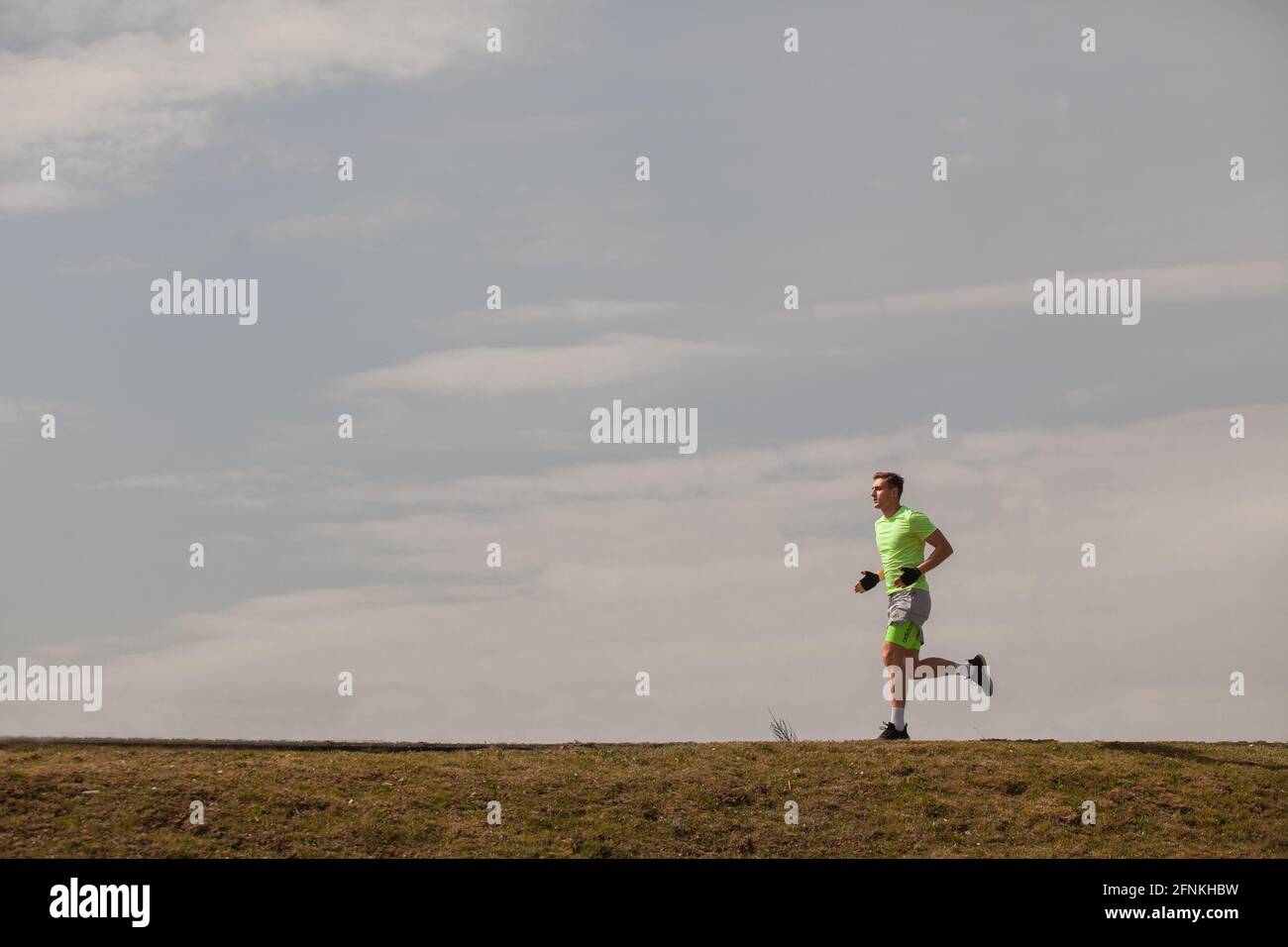 Handsome and attractive male sportsman is running on a clean background ...