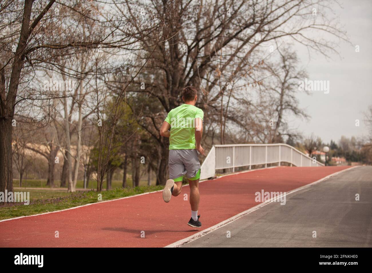 Strong sportsman is running from the back, close up Stock Photo - Alamy