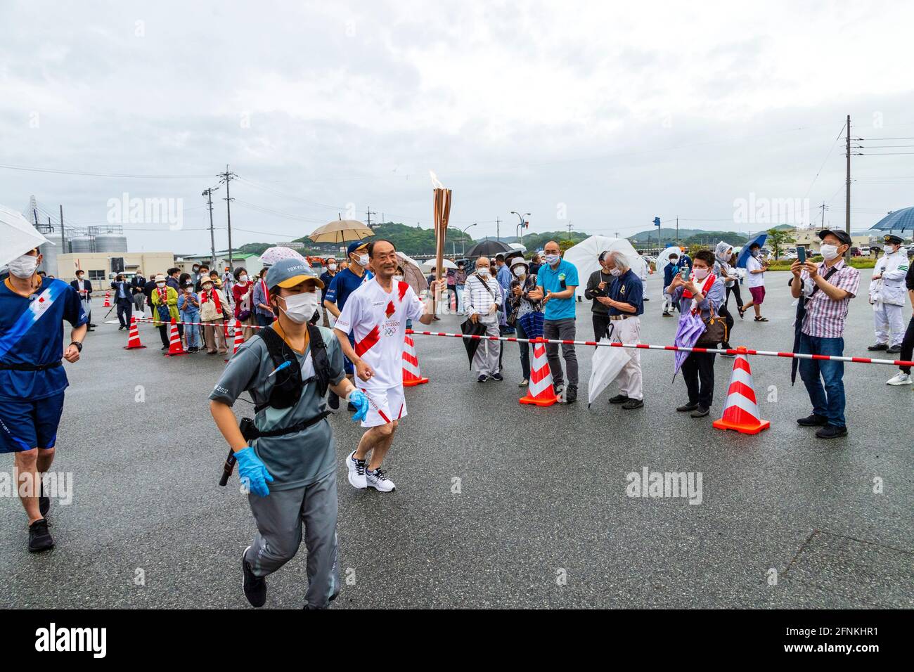 A local torchbearer runs during the Tokyo 2020 Olympic torch relay in ...