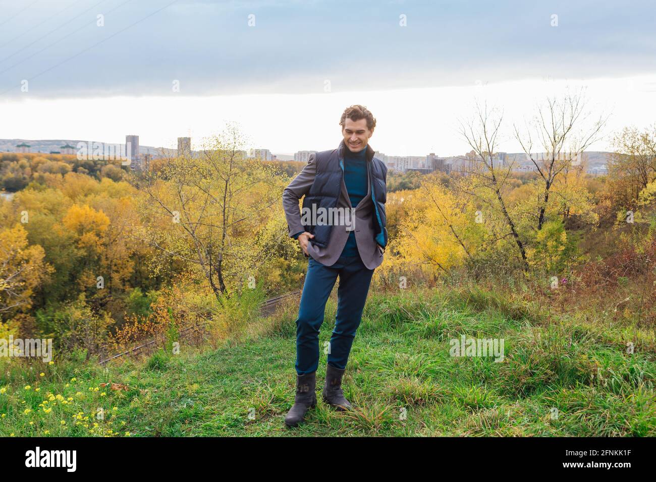 Tall handsome man walking outdoor in yellow autumn forest on the hill ...