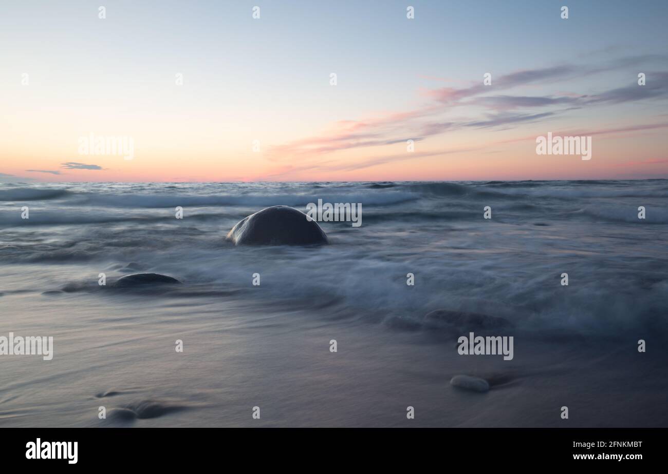 Beautiful ocean sunset with rocks and waves Stock Photo - Alamy