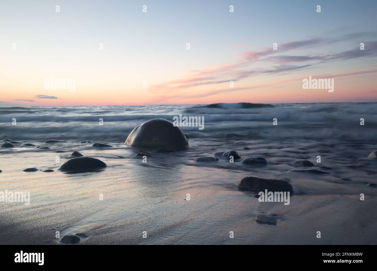 Beautiful ocean sunset with rocks and waves Stock Photo - Alamy