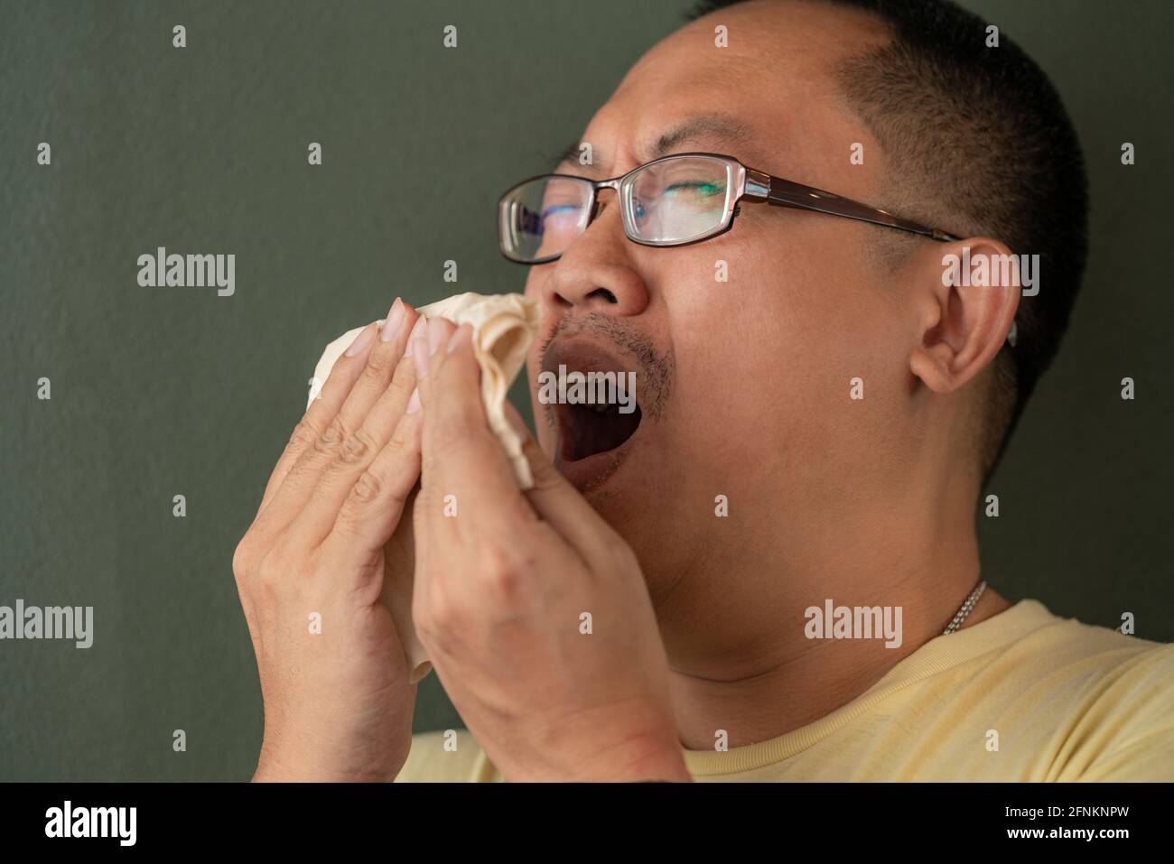 Asian sneezing man with cold Stock Photo - Alamy