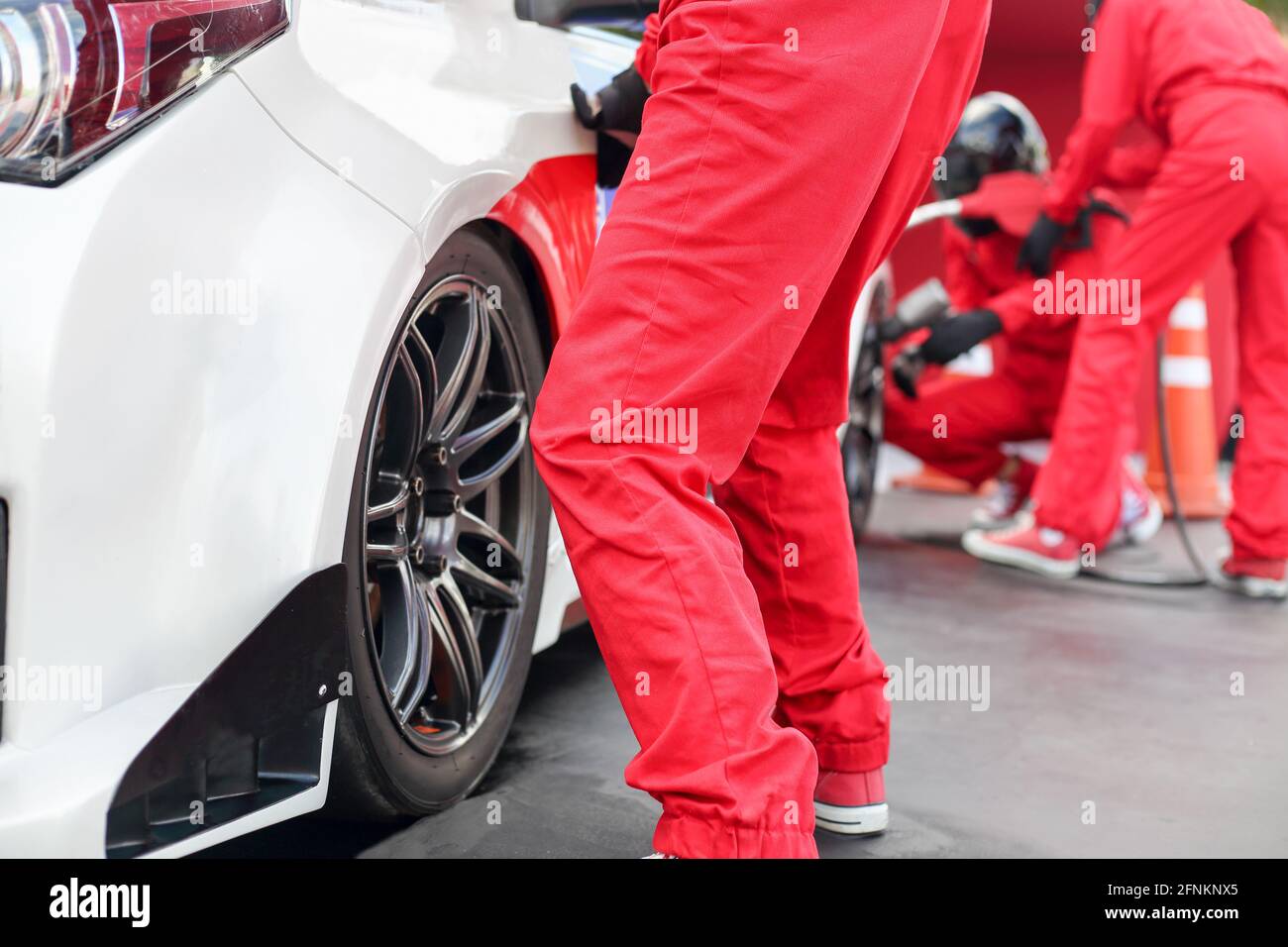 Auto mechanic changing racing car wheel Stock Photo - Alamy