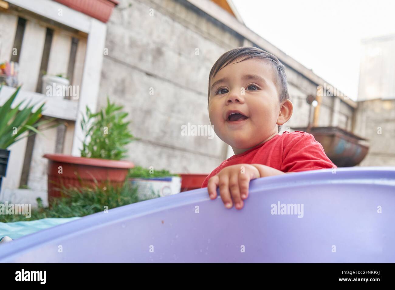 Baby playing in house garden in summer Stock Photo - Alamy